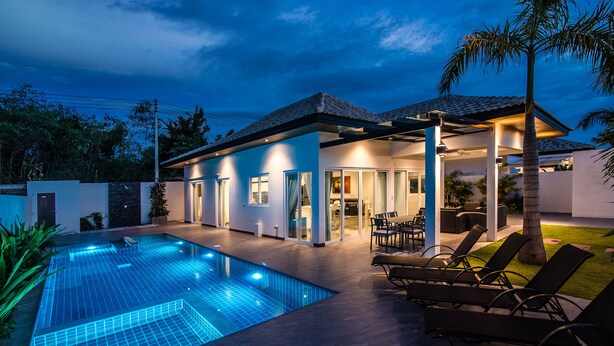 Uma casa moderna com piscina, área de estar externa e varanda coberta.