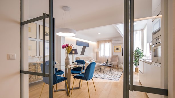 Uma sala de estar moderna com área de refeições, um sofá, uma mesa de centro e um abajur.
