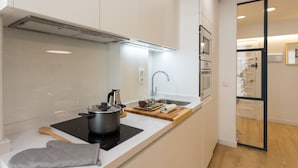 Uma cozinha moderna com fogão, pia e tábua de corte de madeira.
