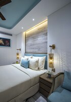 Quarto moderno com cama grande, mesas de cabeceira, luminária fixada na parede e quadro emoldurado.