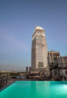 Um edifício moderno e alto com piscina no terraço.