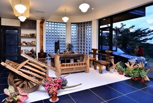 Um interior moderno com uma mesa de madeira e bancos, uma janela grande e vista para o exterior.