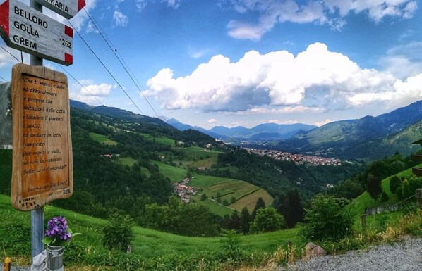 Vista panorâmica de um vale com um sinalizador indicando direções para Belloro, Golla e Grem.