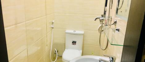 Uma casa de banho pequena com lavatório branco, sanita e chuveiro.