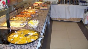 Buffet com diversos pratos e mesa com acompanhamentos.