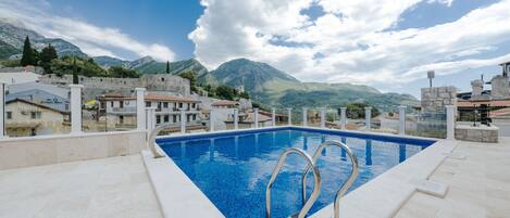 Piscina com vista para montanhas e edifícios.