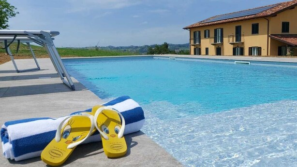 Piscina com uma casa ao fundo.