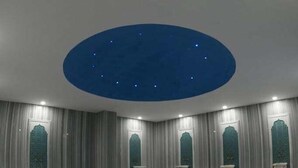 Quarto com teto estrelado, área de estar central e piso estampado.