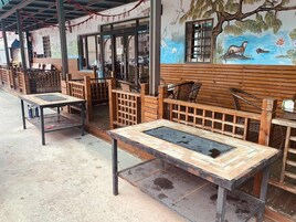 Um restaurante com mobiliário de madeira e um mural com animais na parede.