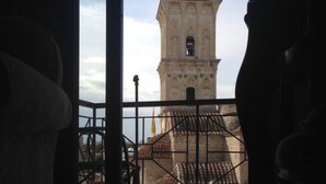 Quarto com vista para uma torre histórica através de uma janela.