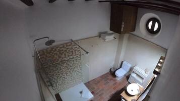 Casa de banho compacta com chuveiro, sanita e lavatório.