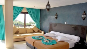 Quarto de hotel com cama, sofá e vista para o exterior.