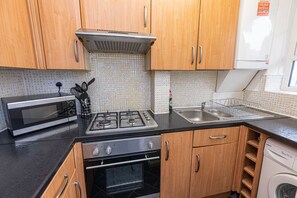 Um frigorífico, um micro-ondas, um forno, uma placa de cozinha 