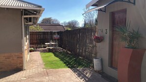 Propriedade privada com quintal cercado, mesa para piquenique e um pequeno jardim.
