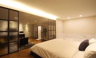 Quarto moderno com cama grande, closet espaçoso e banheiro com parede de mármore.