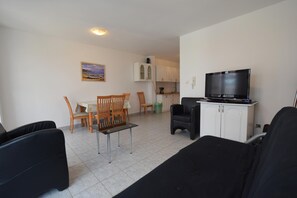 Apartamento, 2 quartos | Sala de estar | TV de ecrã plano 