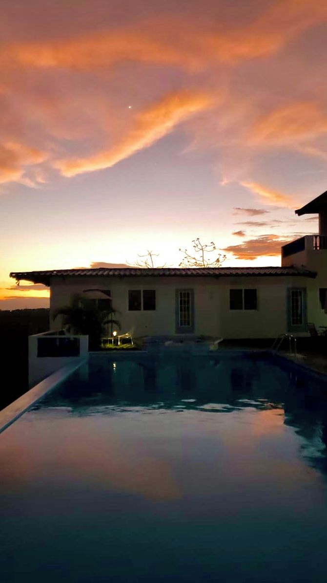 Uma casa moderna com piscina ao pôr do sol.