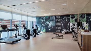 Academia moderna com esteiras, bicicletas ergométricas e aparelhos de musculação.