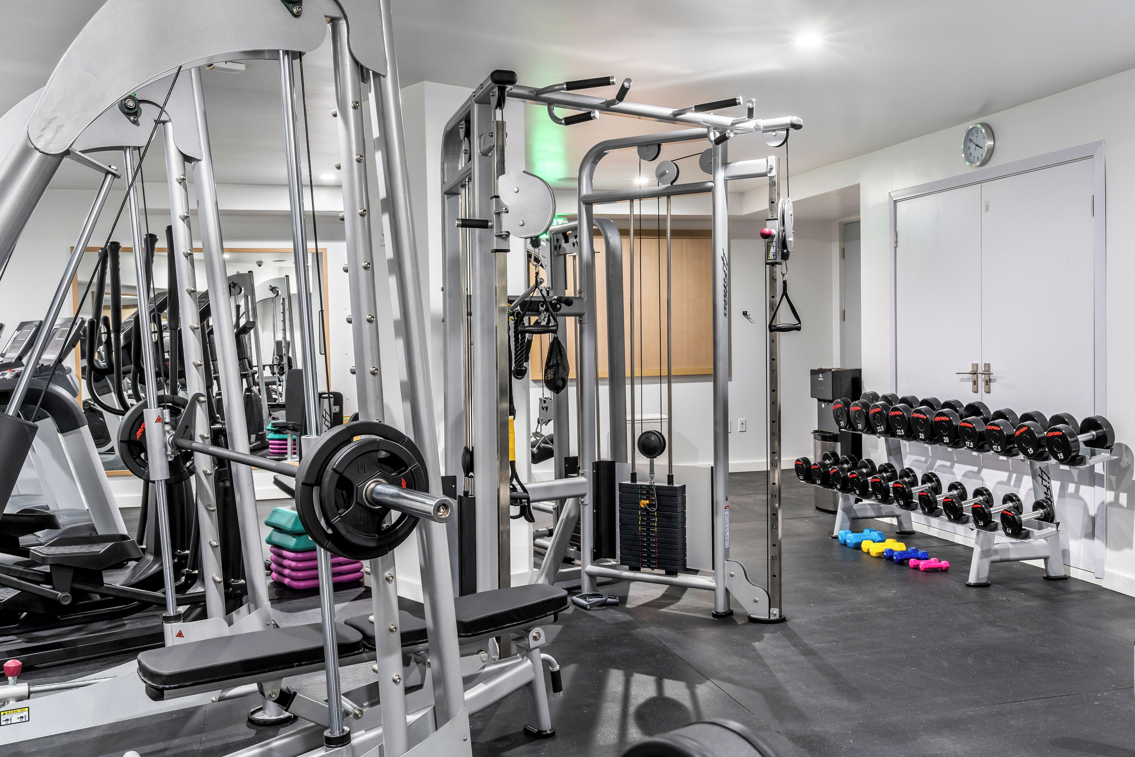 Uma academia com diversos equipamentos de exercício, incluindo máquinas de peso e halteres.