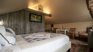 Quarto com cabeceira de madeira, colcha, escrivaninha e cadeira.