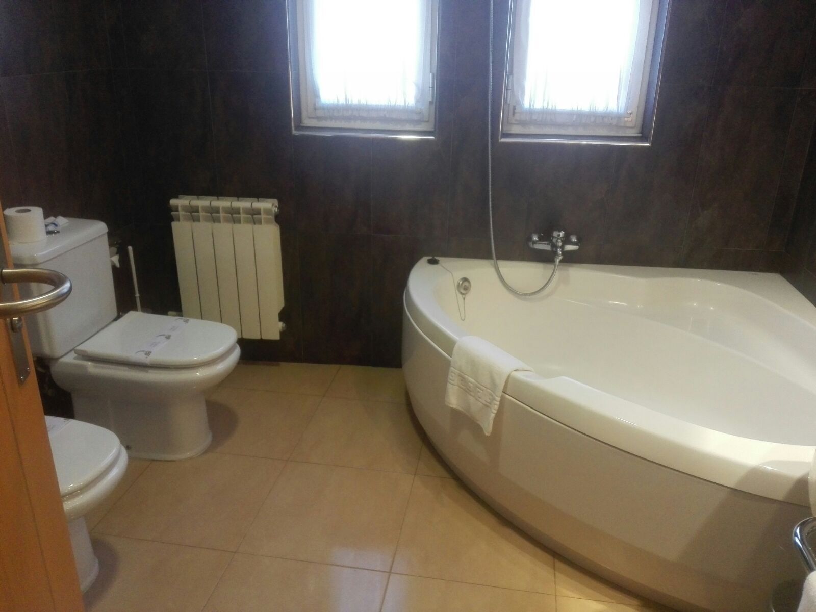 Um banheiro com banheira, vaso sanitário e radiador.