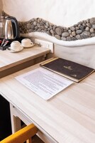 Uma mesa de madeira com um menu, chaleira, xícaras e um tabuleiro.