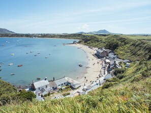 Uma vila costeira com uma praia, barcos e casas.