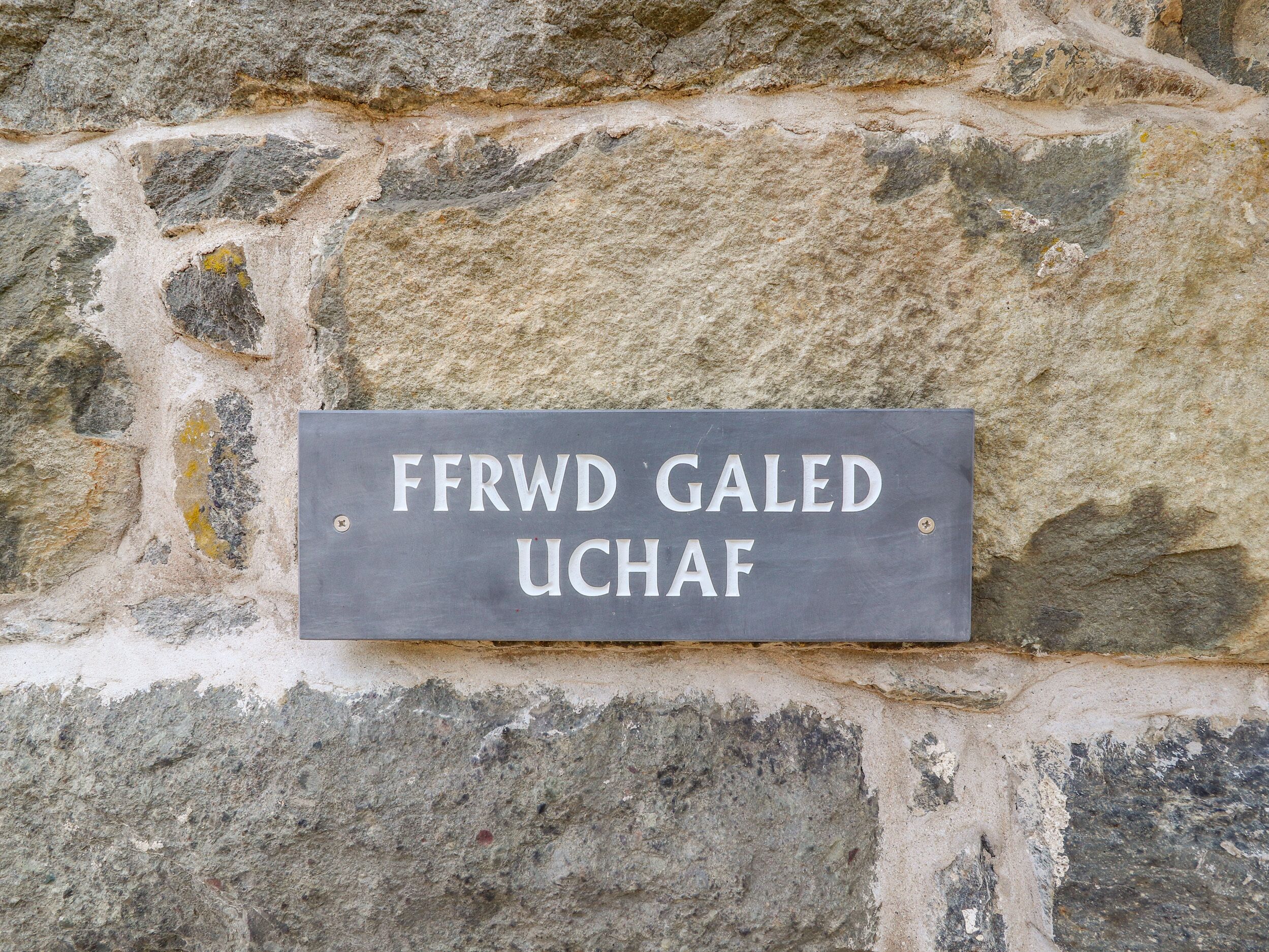 Paredes de pedra com uma placa que diz 'FFRWD GALED UCHAF'.