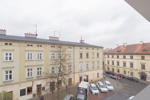 Fileira de edifícios amarelos com várias janelas e telhado de telhas vermelhas.