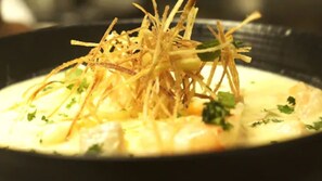 Prato com ingredientes desfiados e ervas em uma tigela preta.