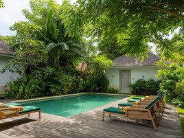 Uma área de piscina com espreguiçadeiras e um pequeno edifício.