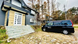 Uma casa moderna de dois andares com um carro estacionado na frente.