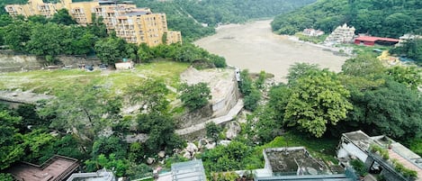 Hotel com piscina, área de estar externa e vista para o rio.