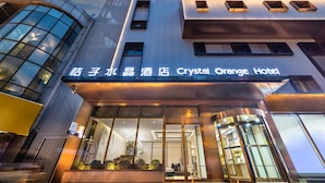 Exterior do Hotel Crystal Orange com design moderno, destacando grandes janelas e uma placa bem visível.