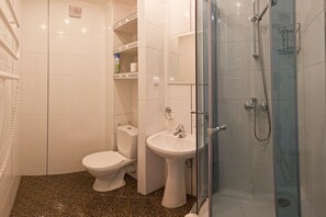 Apartamento | Casa de banho | Uma combinação polibã/banheira, um secador de cabelo, roupões, chinelos 