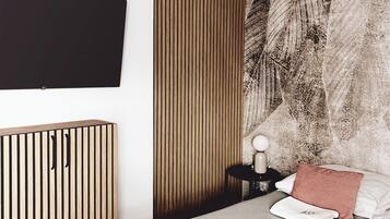 Quarto moderno com cama, mesa de cabeceira, luminária, TV e parede com textura.