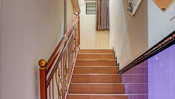 Uma escadaria com degraus de madeira e corrimão de metal com detalhes decorativos.