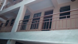 Um edifício com vários andares, varandas, janelas amplas e fachada plana.