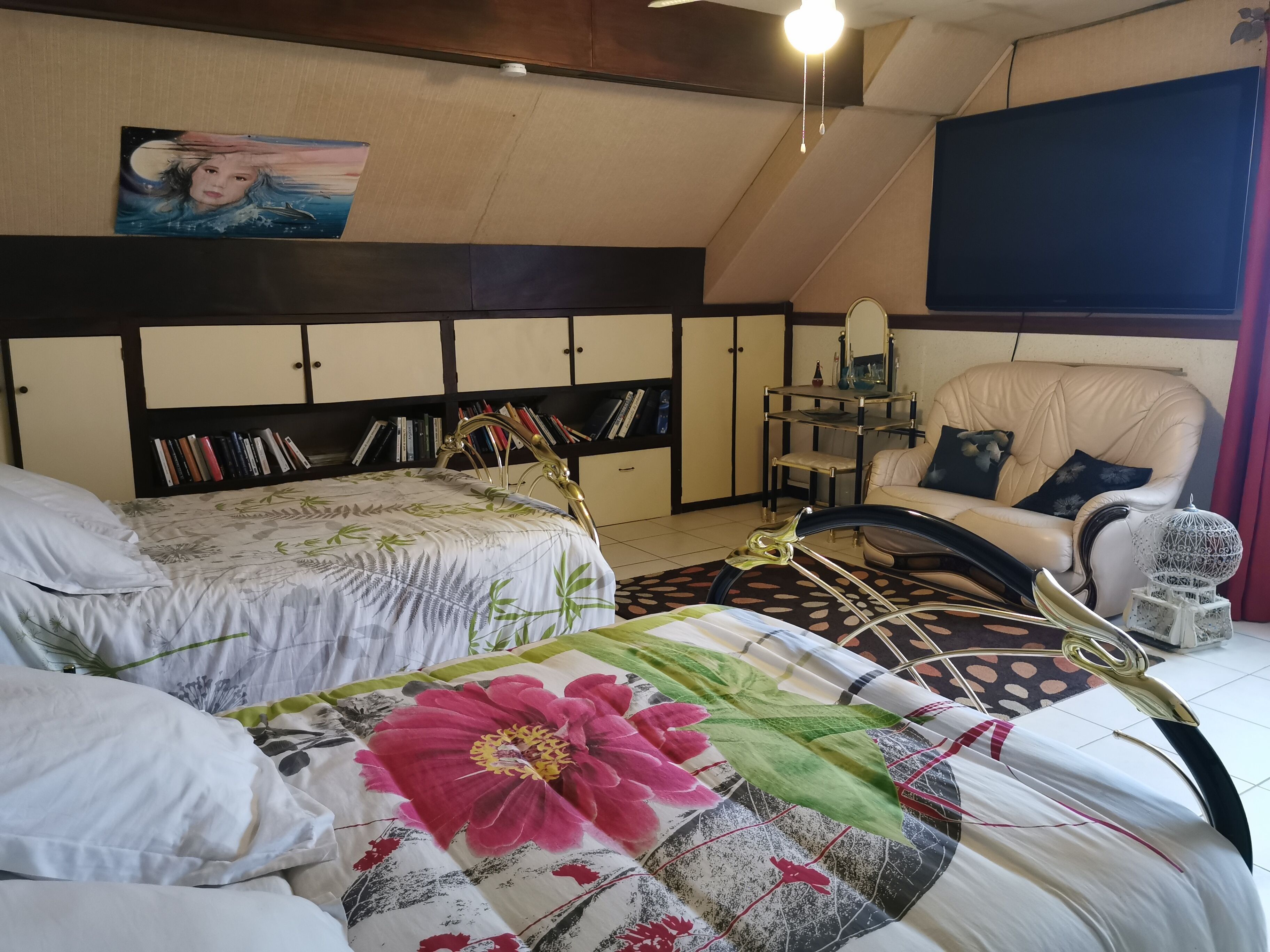 Um quarto com uma cama, uma cadeira, uma escrivaninha e uma estante de livros.