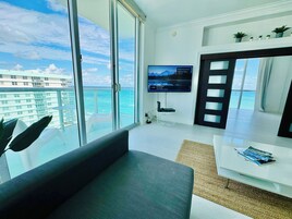 Penthouse Panorâmica, 2 quartos, varanda, vista para o oceano | Sala de estar | Televisor de ecrã plano de 32 polegadas com canais por cabo, televisor 