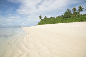 Perto da praia, praia de areia branca, espreguiçadeiras 