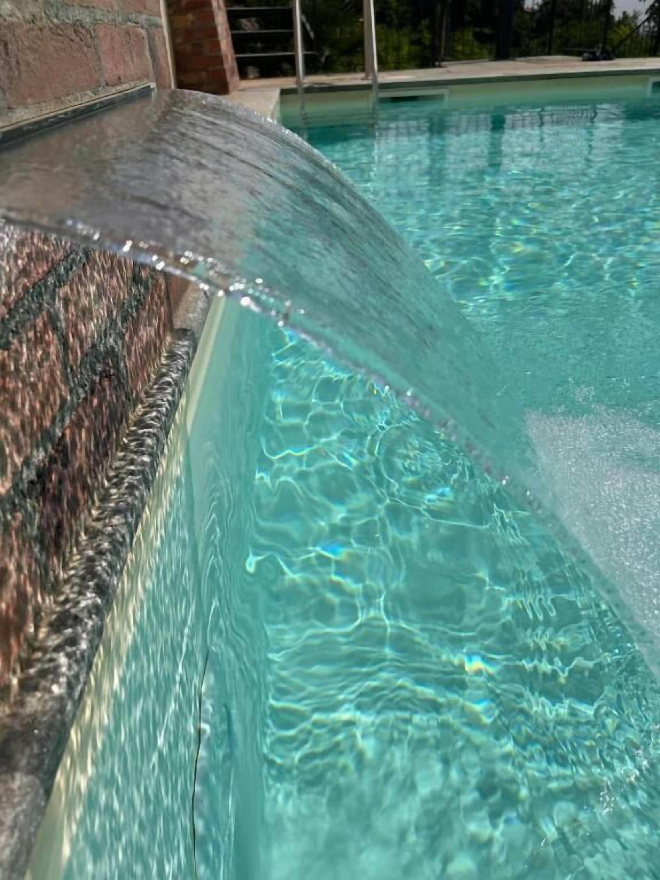 Piscina límpida com cascata.