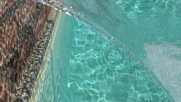 Piscina límpida com cascata.