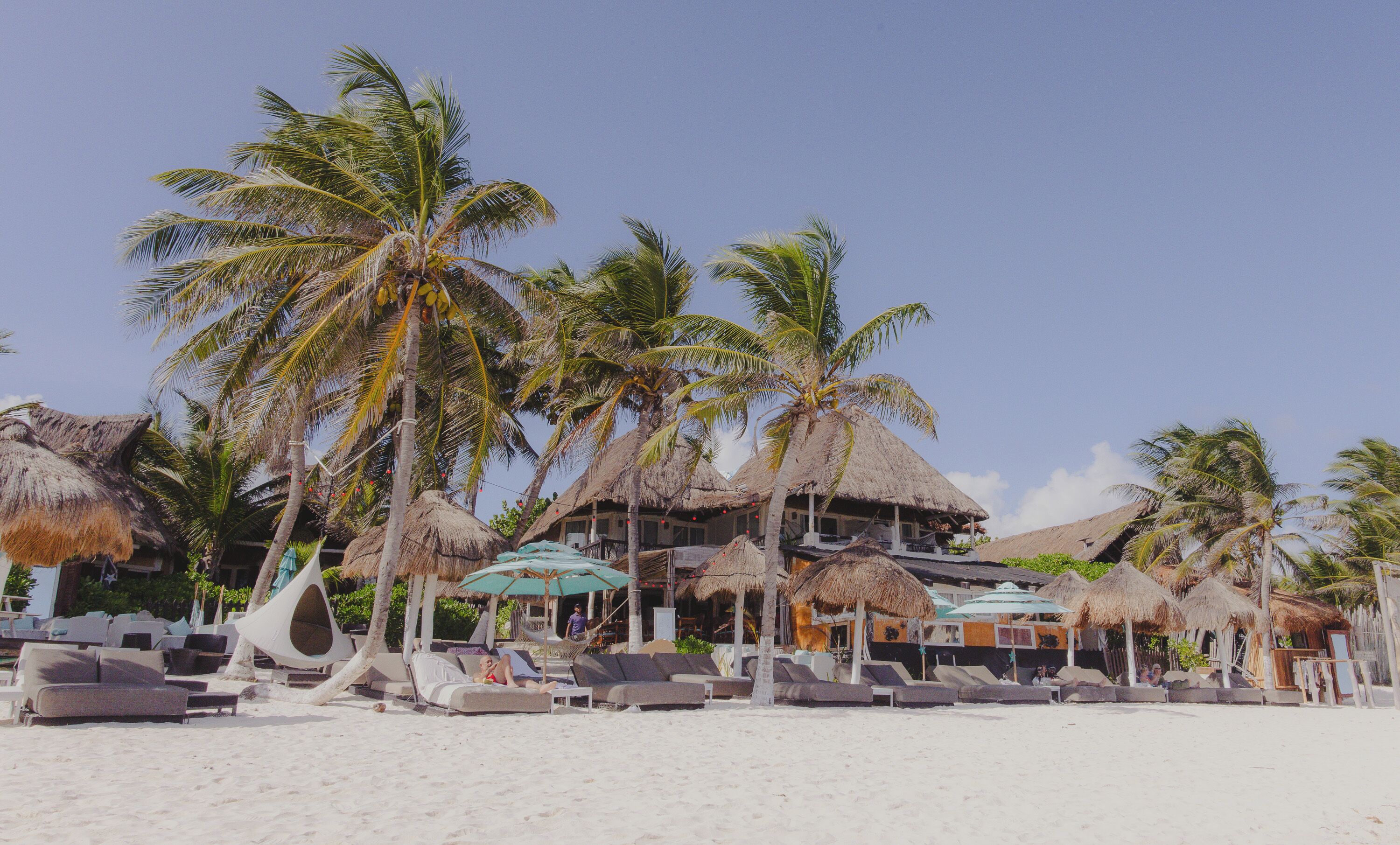 Praia particular, areia branca, espreguiçadeiras, guarda-sóis 