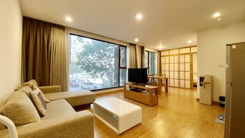 Uma sala de estar moderna com um sofá, TV e uma mesa de centro de madeira.