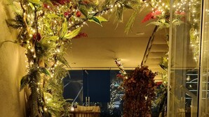 Um espaço interno aconchegante com piso estampado, móveis de madeira e plantas decorativas.