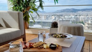 Uma mesa de jantar com pizza, uma salada, queijos e nozes variados.