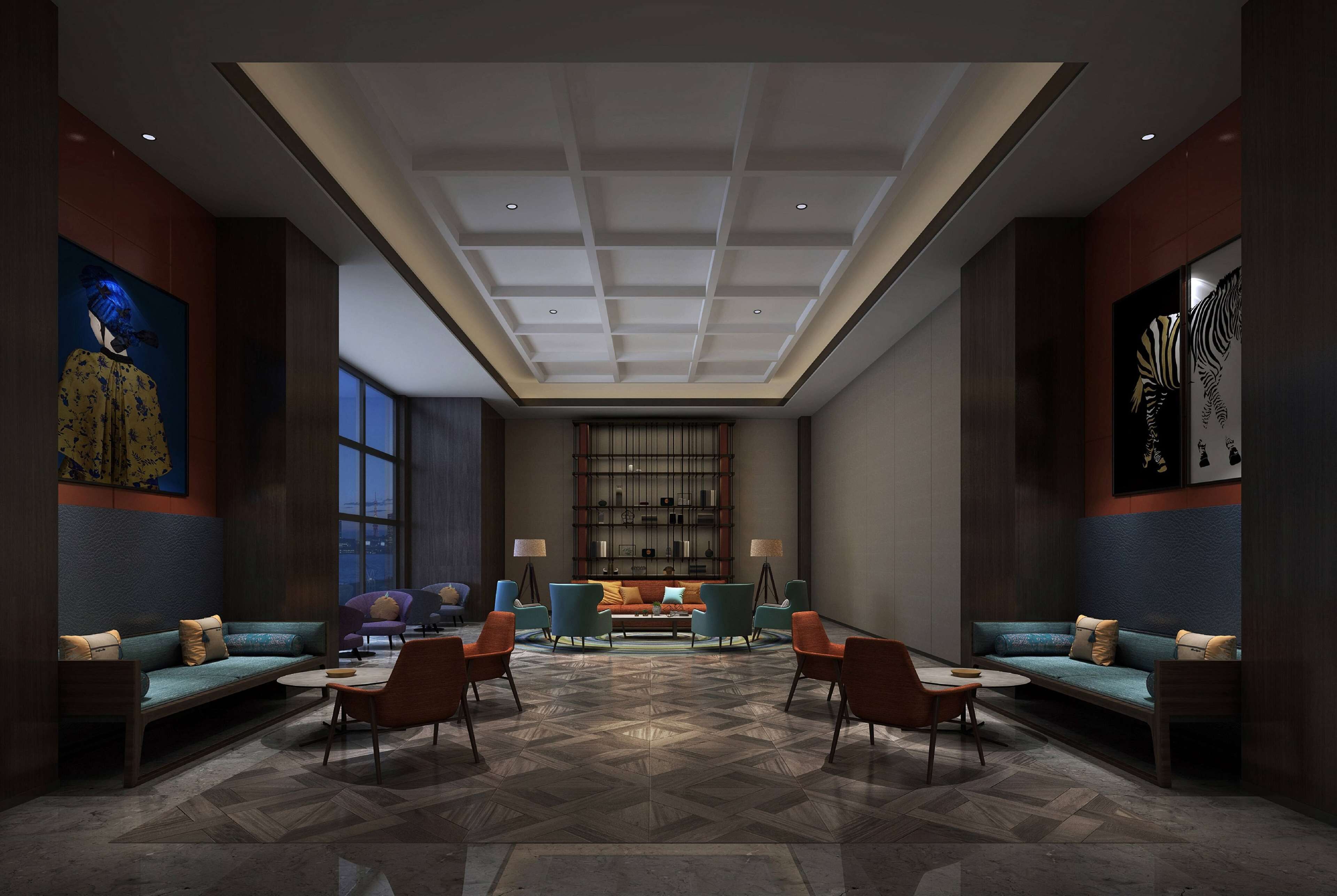 Um lobby moderno com área de estar central, piso estampado e teto com iluminação embutida.