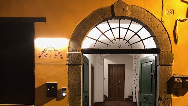 Uma entrada com arco de pedra que dá acesso a uma escadaria.