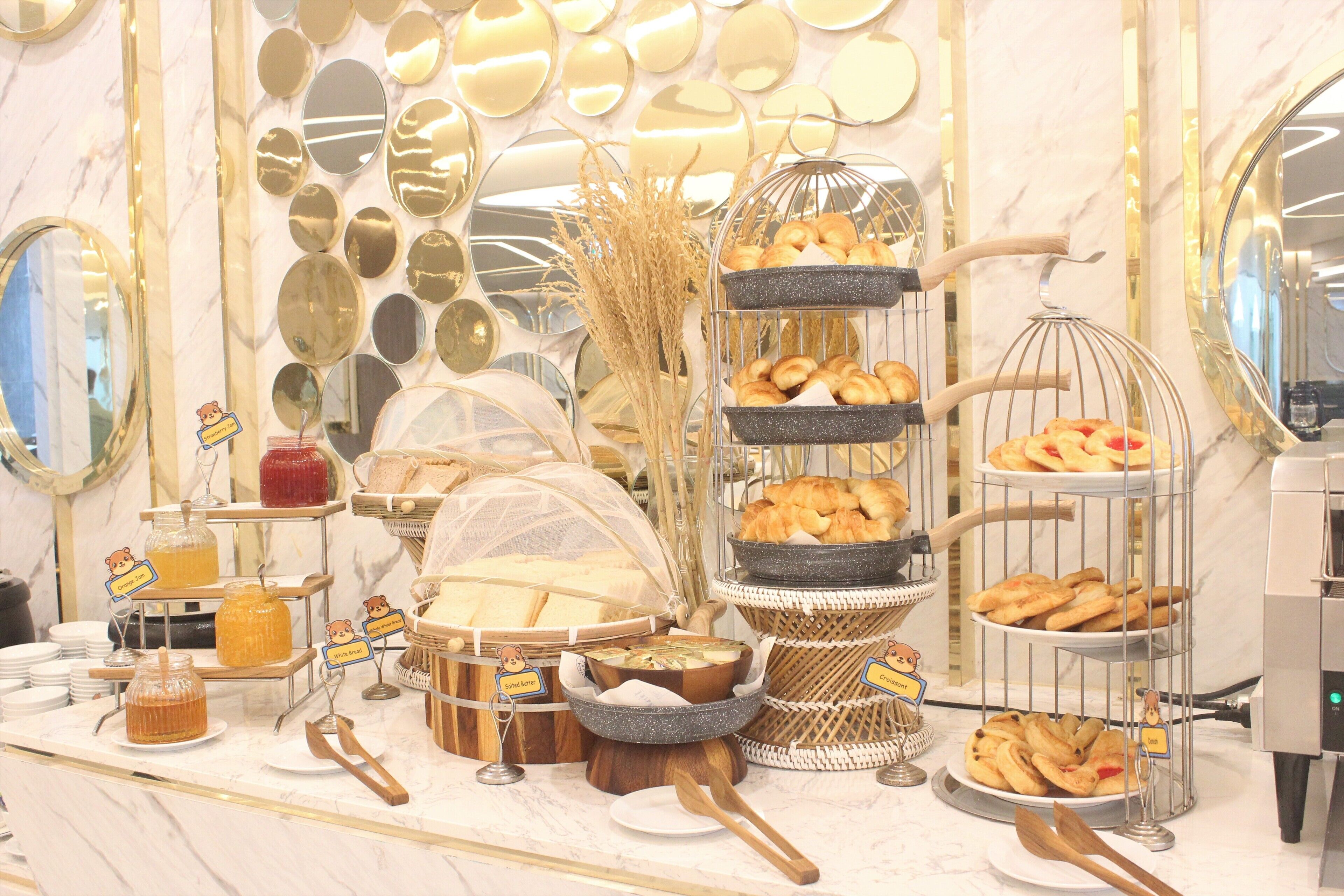 Um buffet de café da manhã com diversas opções de comida e uma máquina de café.